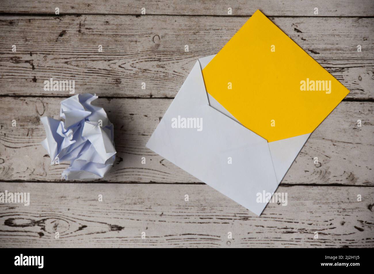 Top view of empty envelope with crumpled paper and wooden table ...