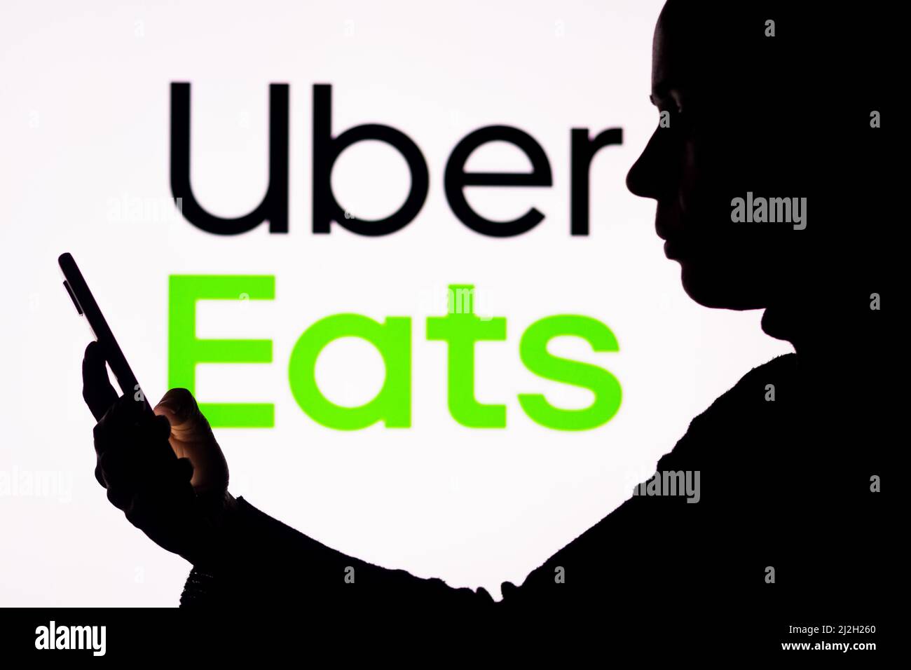 In this photo illustration, a woman's silhouette holds a smartphone ...