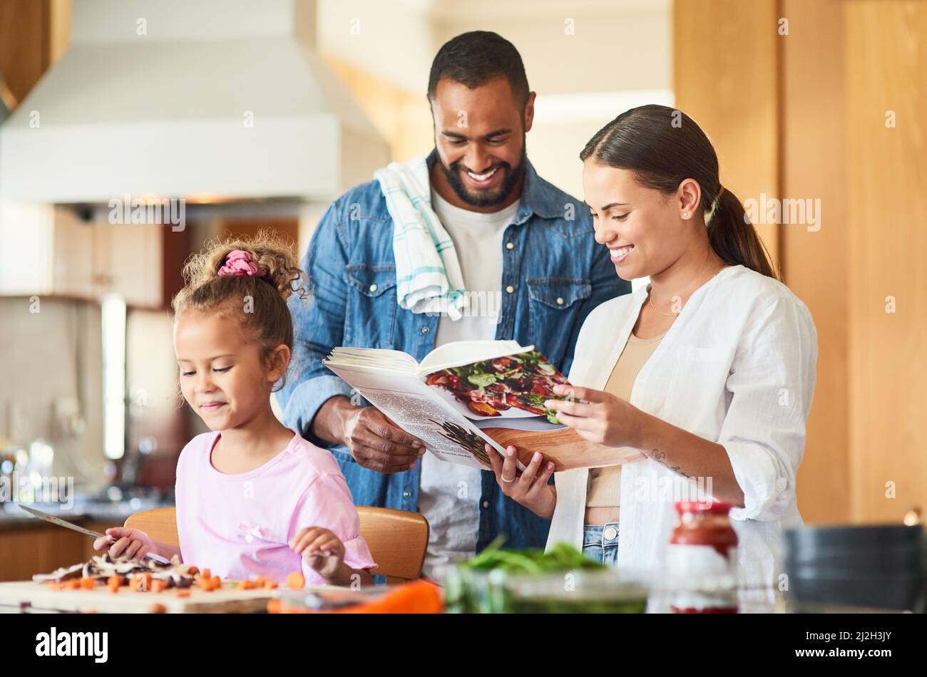Were learning to cook as a family. Shot of a couple and their daughter ...