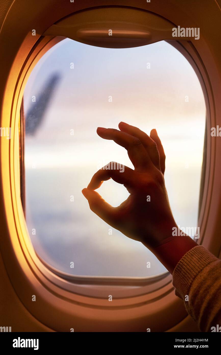 This flight is going just fine. Shot of a passenger making an okay sign ...