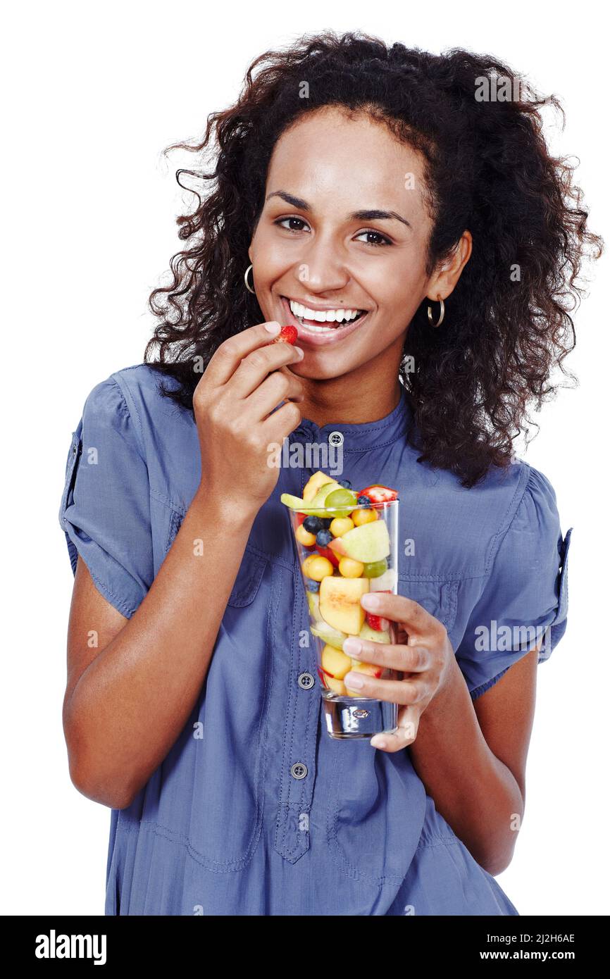 Does my body good. Studio portrait of a smiling woman eating fruit ...