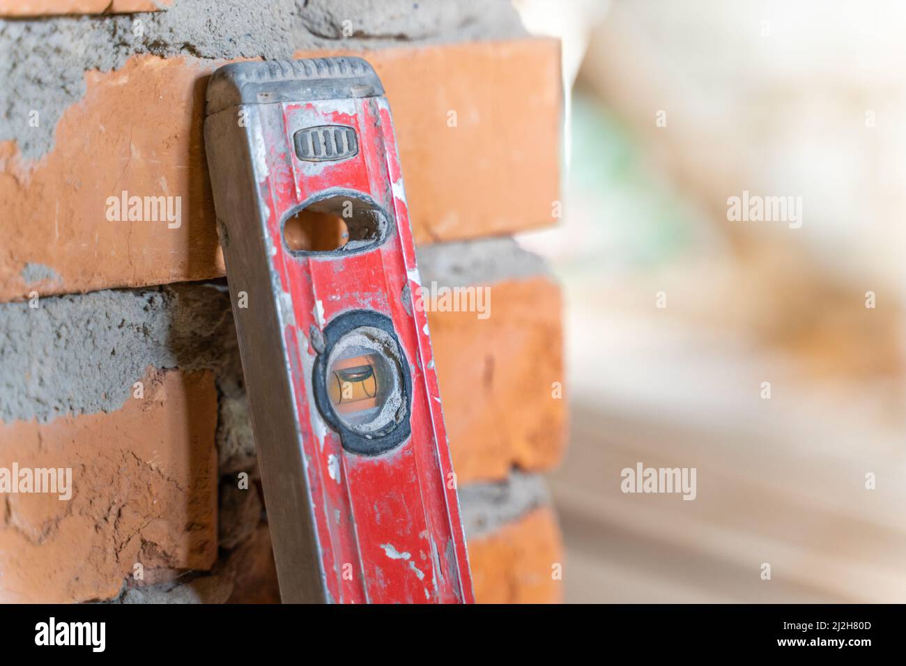 Construction level of red color at a construction site stale on a brick ...
