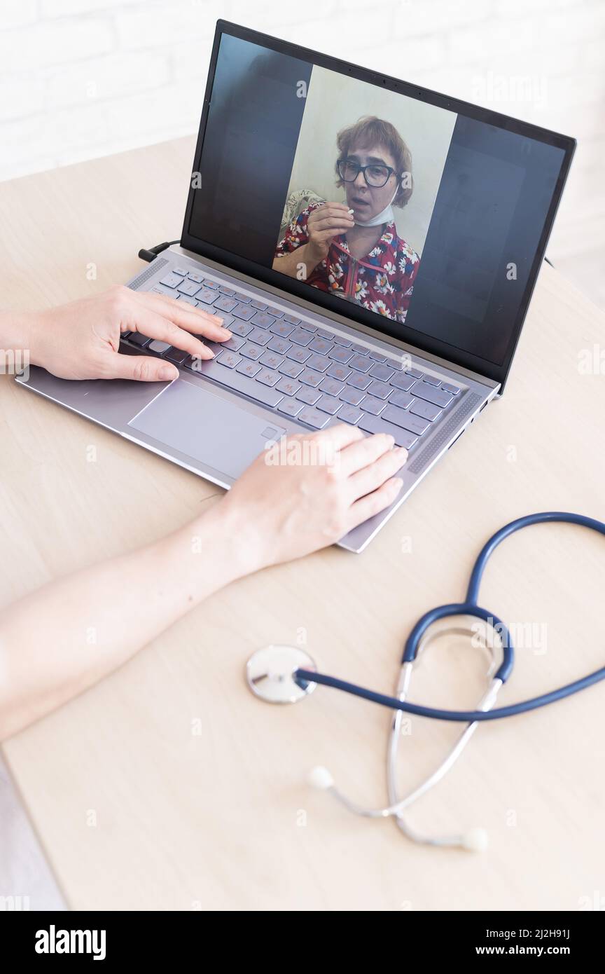 gp hosts an online appointment with an elderly quarantined patient at ...