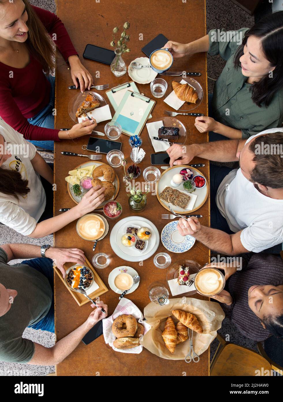Overhead view of group of friends enjoying breakfast at restaurant ...