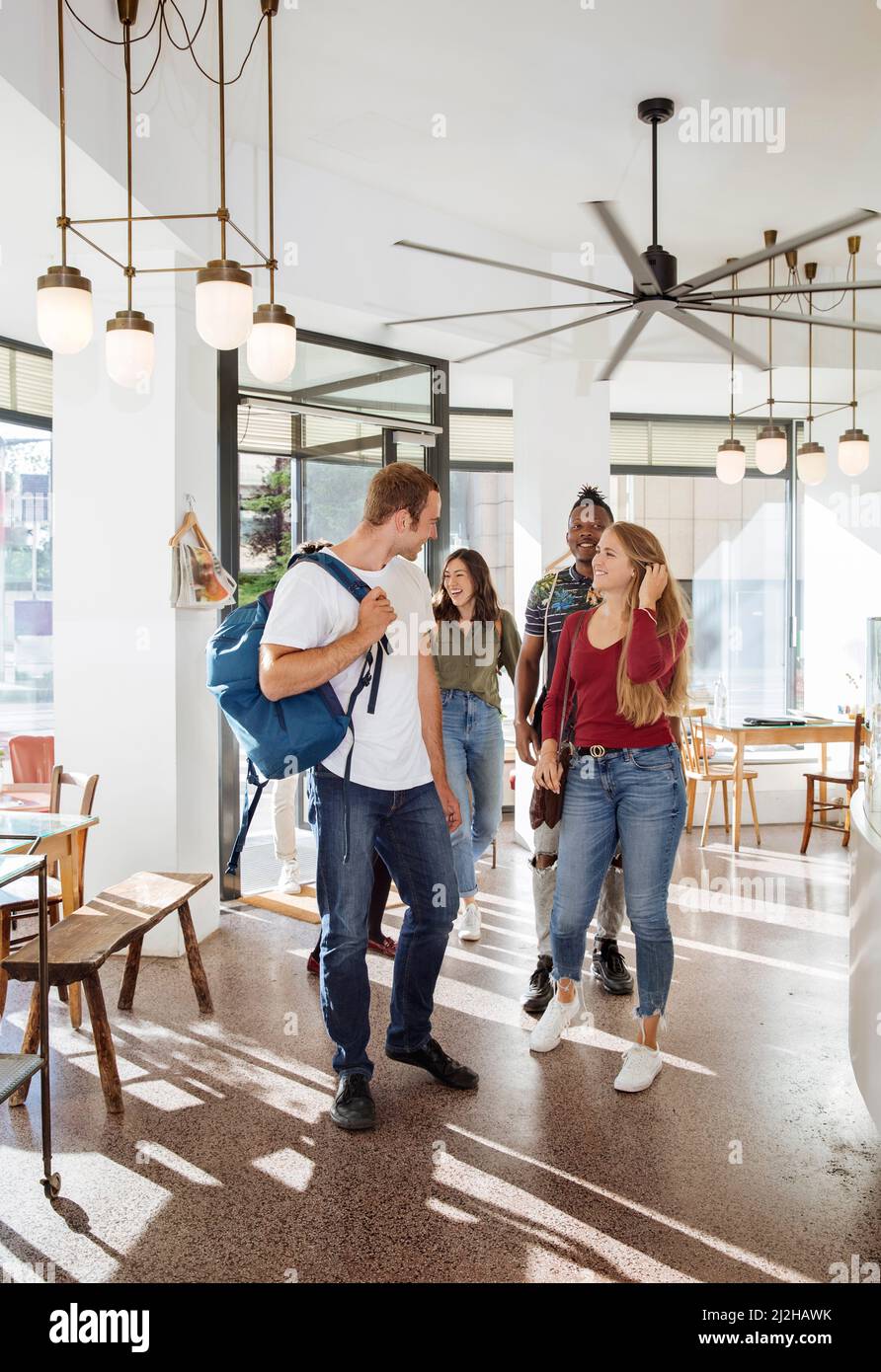 Group of friends entering restaurant Stock Photo - Alamy