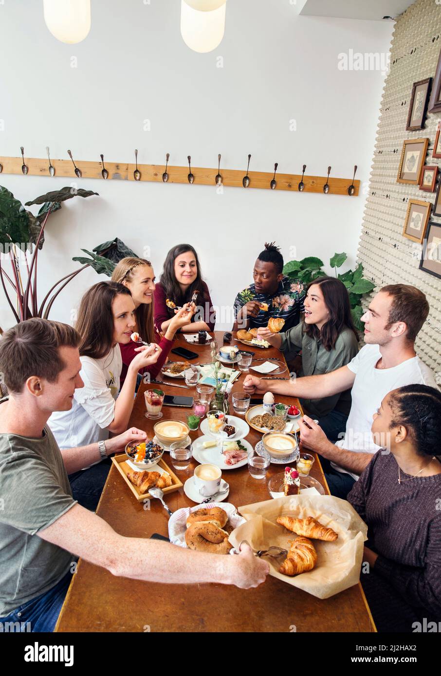 Group of smiling friends enjoying breakfast in restaurant Stock Photo ...