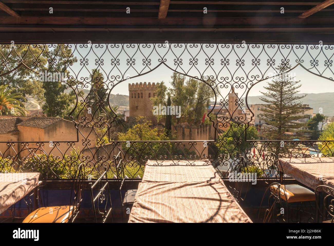 Morocco, Chefchaouen, Restaurant tables with fortress in background ...