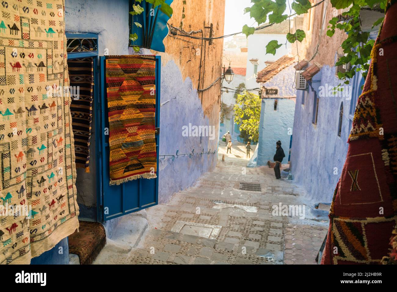 Morocco, Chefchaouen, Narrow alley and houses with rugs for sale Stock ...