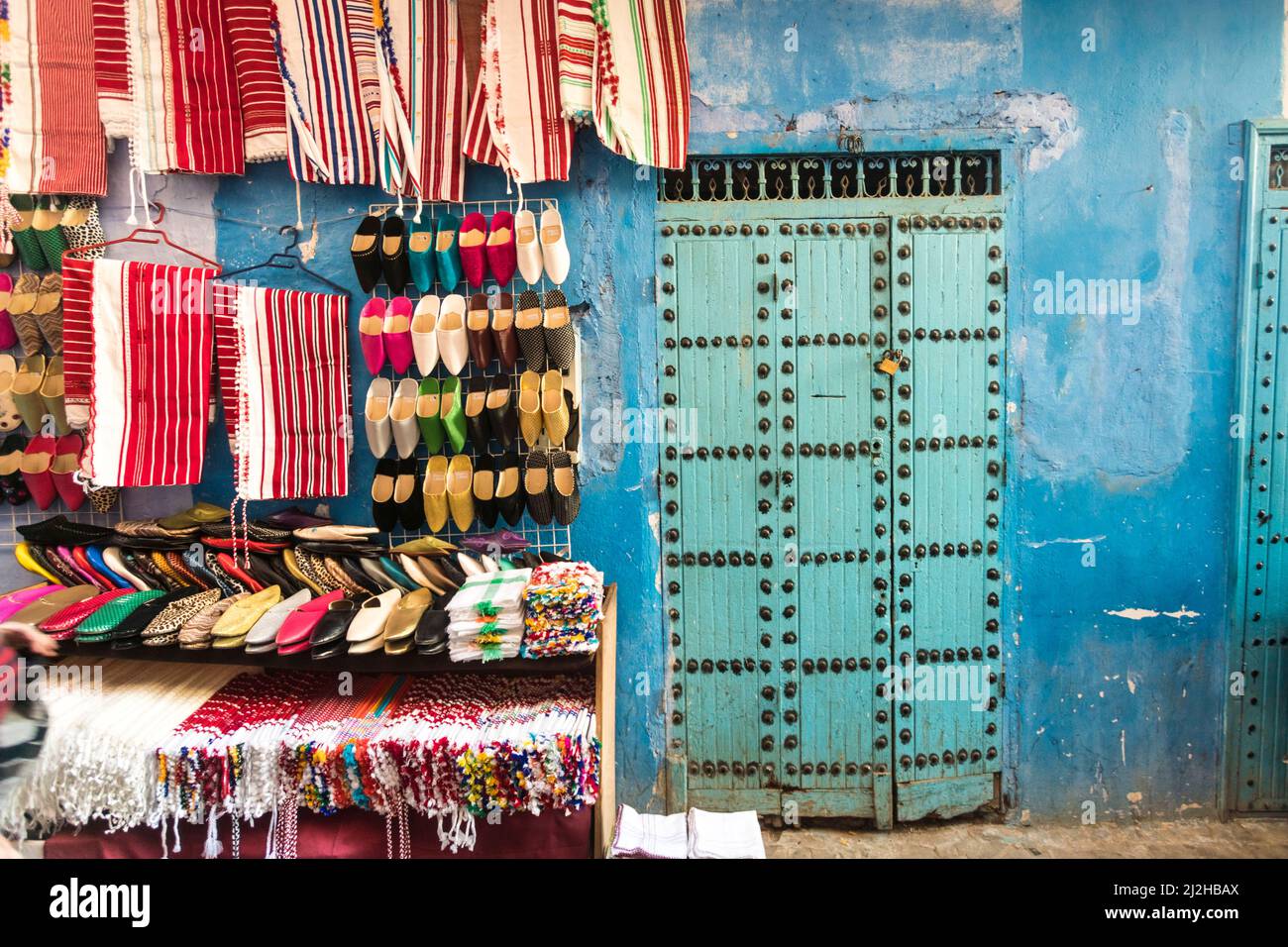 Morocco, Chefchaouen, Textiles and slippers for sale on souk Stock ...