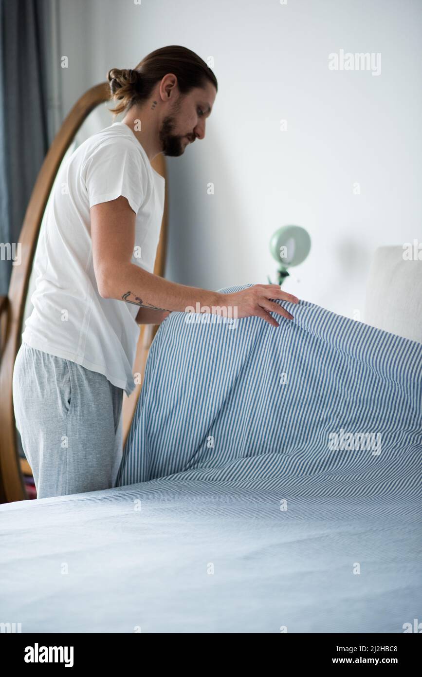 Man making bed Stock Photo - Alamy