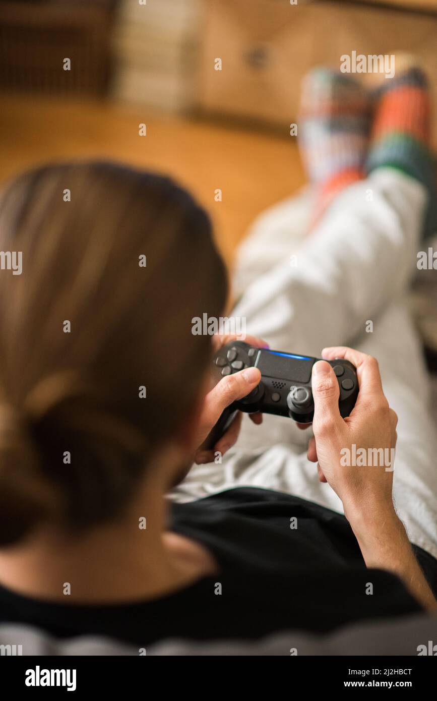 Rear view of man playing video game at home Stock Photo - Alamy