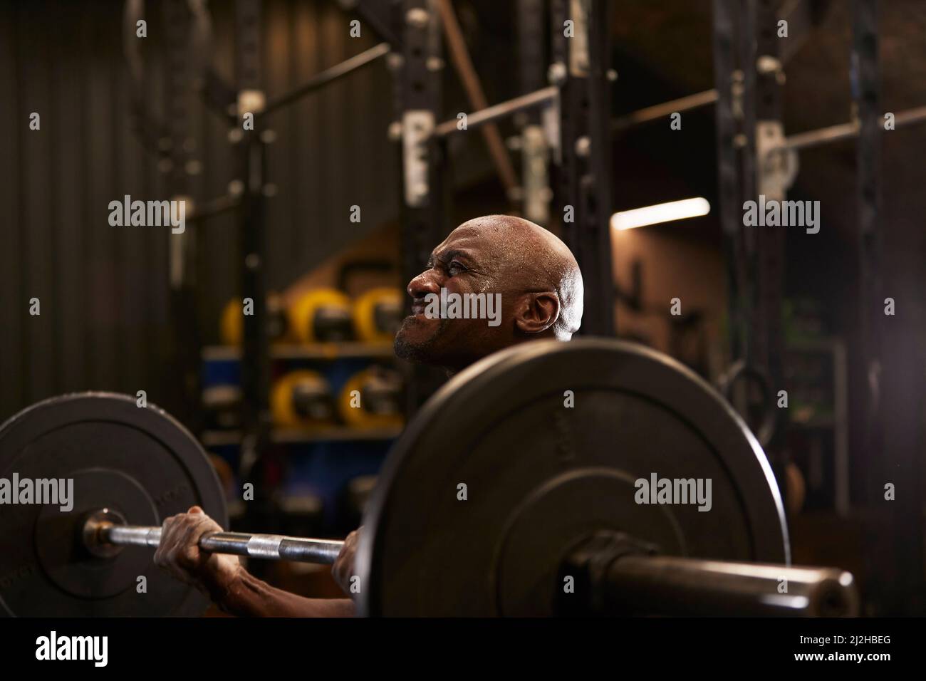 Man with sweat on face weightlifting in gym Stock Photo - Alamy