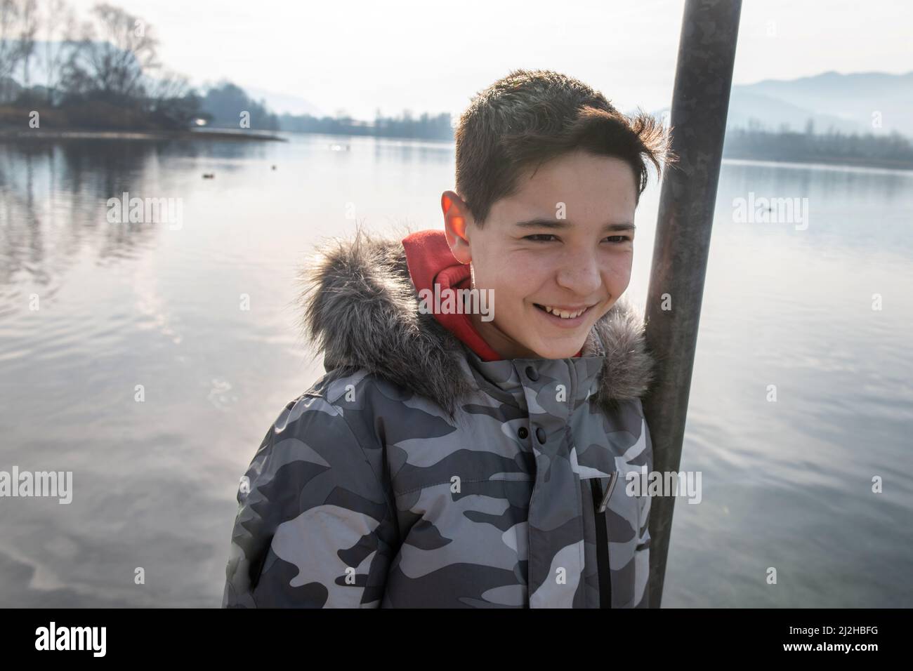 Italy, Smiling boy, by calm lake Stock Photo - Alamy