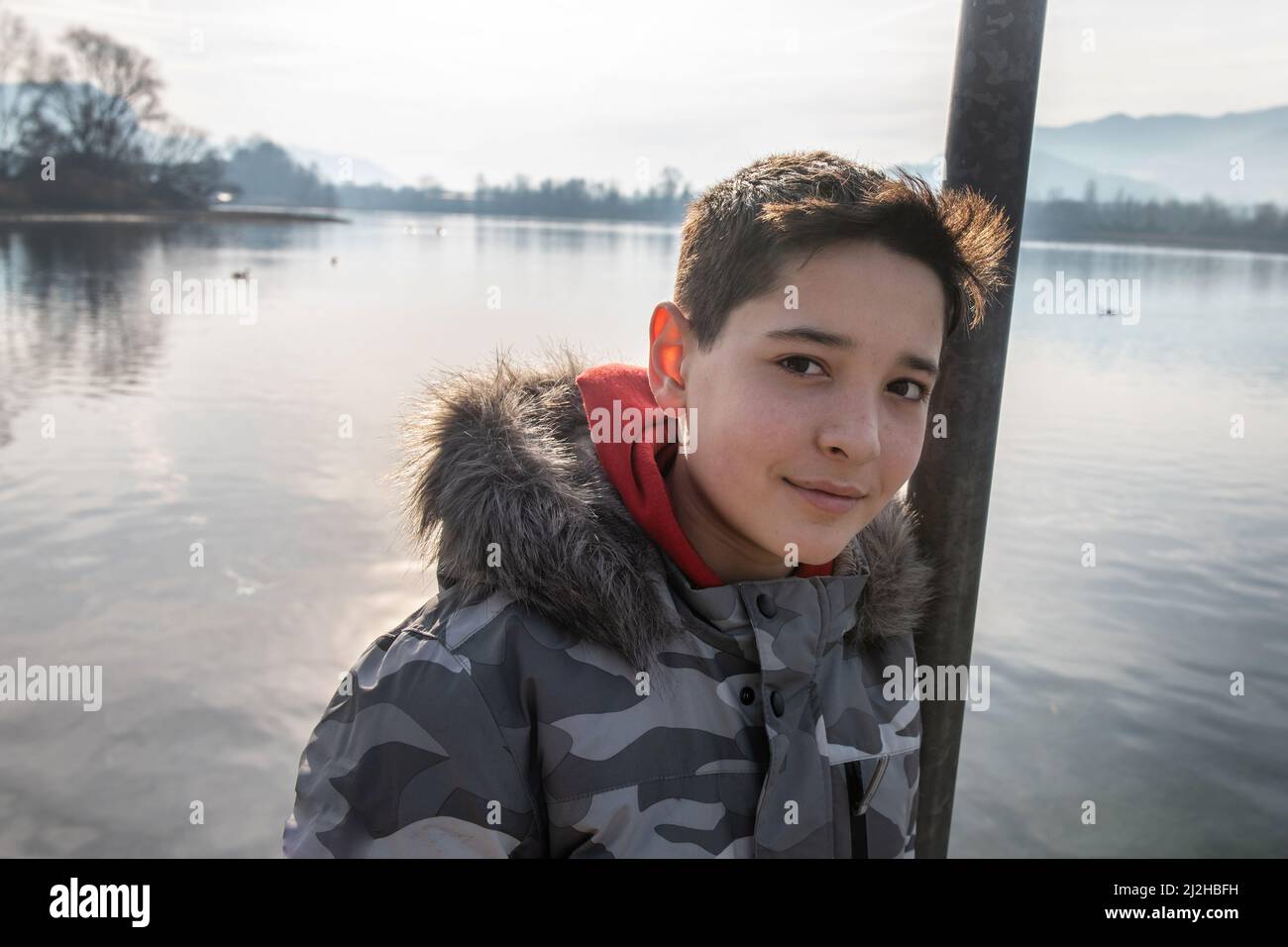 Italy, Portrait of smiling boy, by calm lake Stock Photo - Alamy