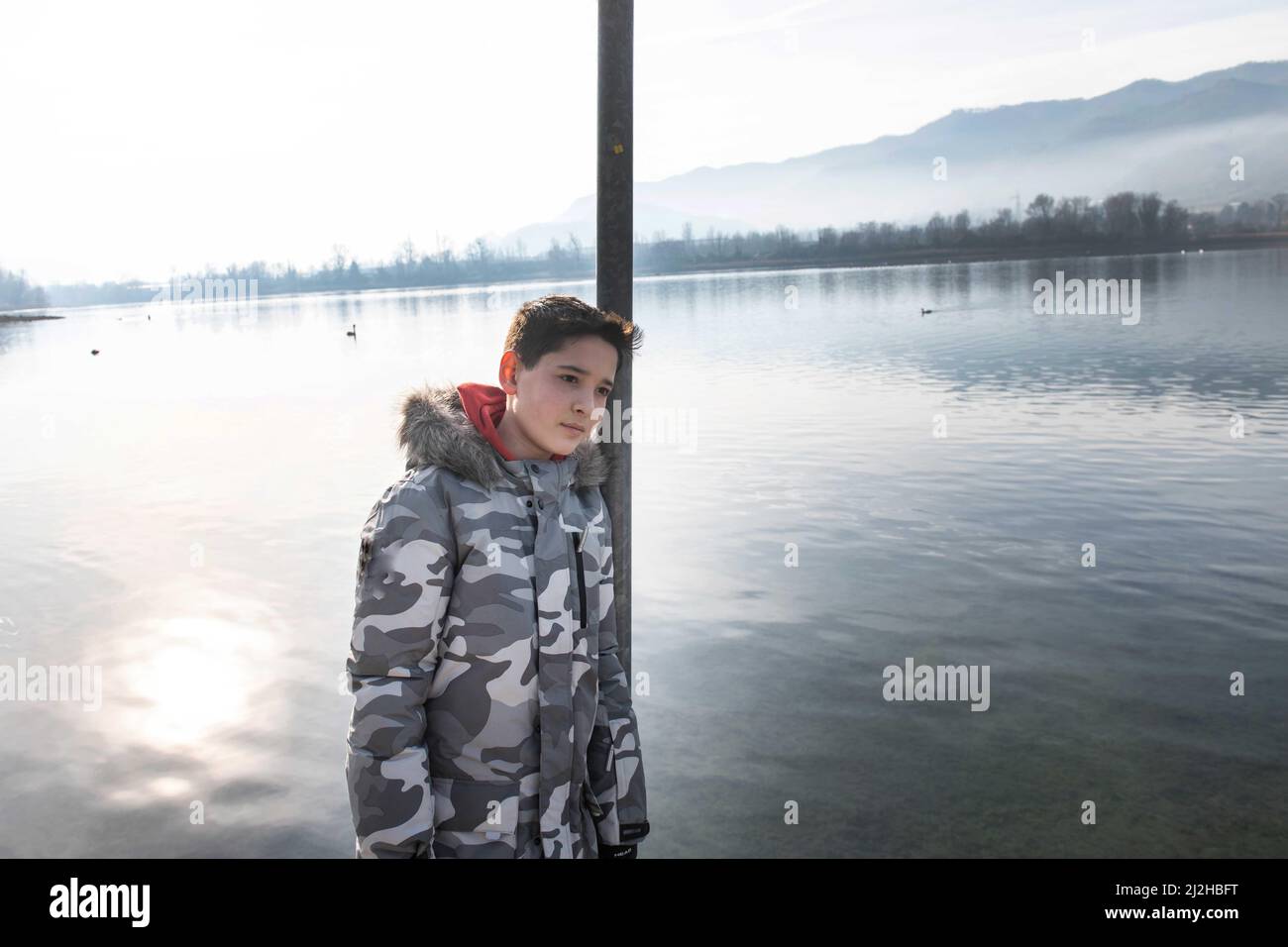 Italy, Pensive boy, by calm lake Stock Photo - Alamy