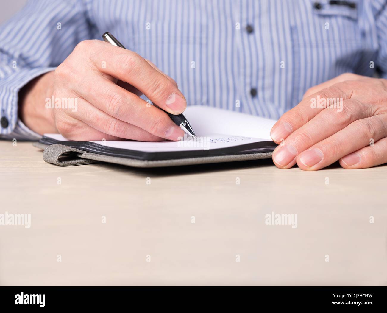Man taking notes in planner. Hands closeup writing information, agenda ...