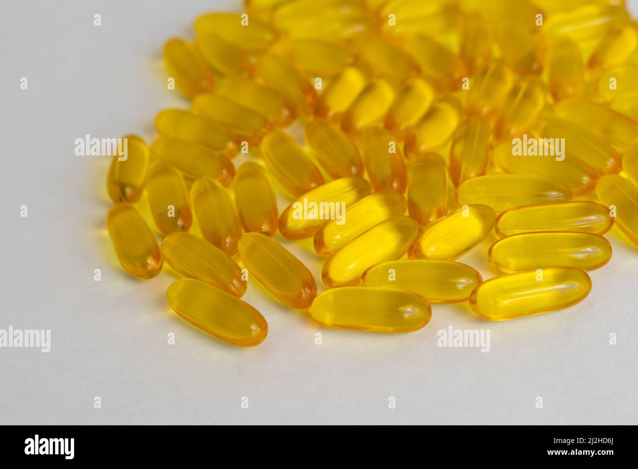 A closeup of bright glowing yellow flaxseed oil capsules containing ...