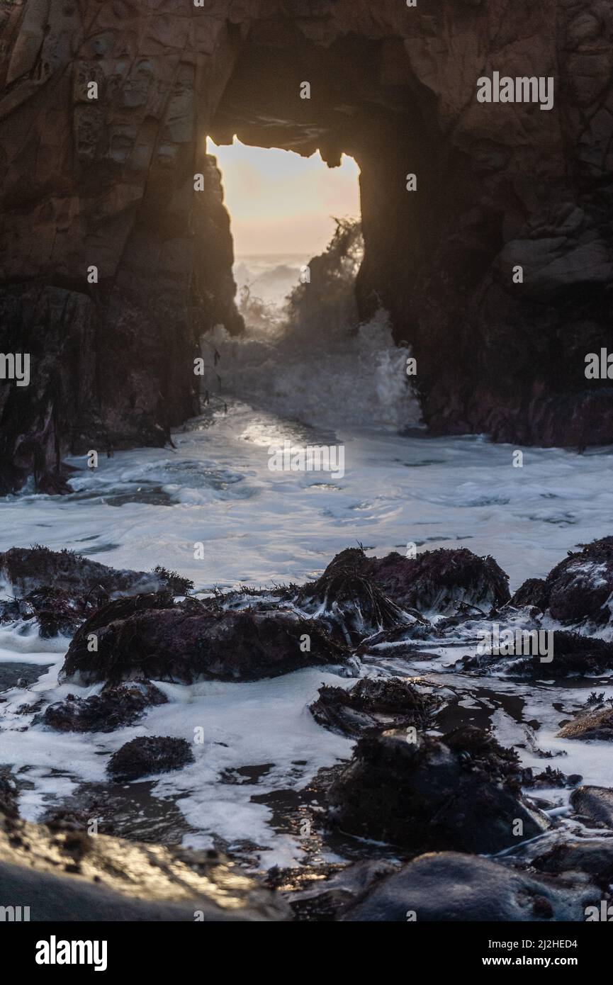 A sunset sky peeping thought the keyhole arch at Pfeiffer Beach, near ...
