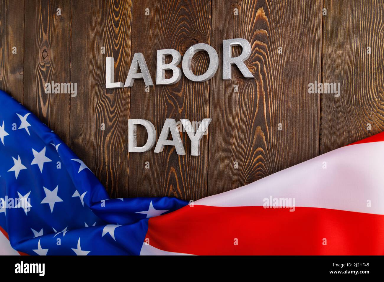 words labor day laid with silver metal letters on wooden surface with ...