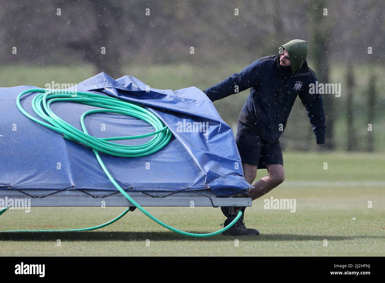 The covers are brought on during a brief snow shower during Middlesex ...