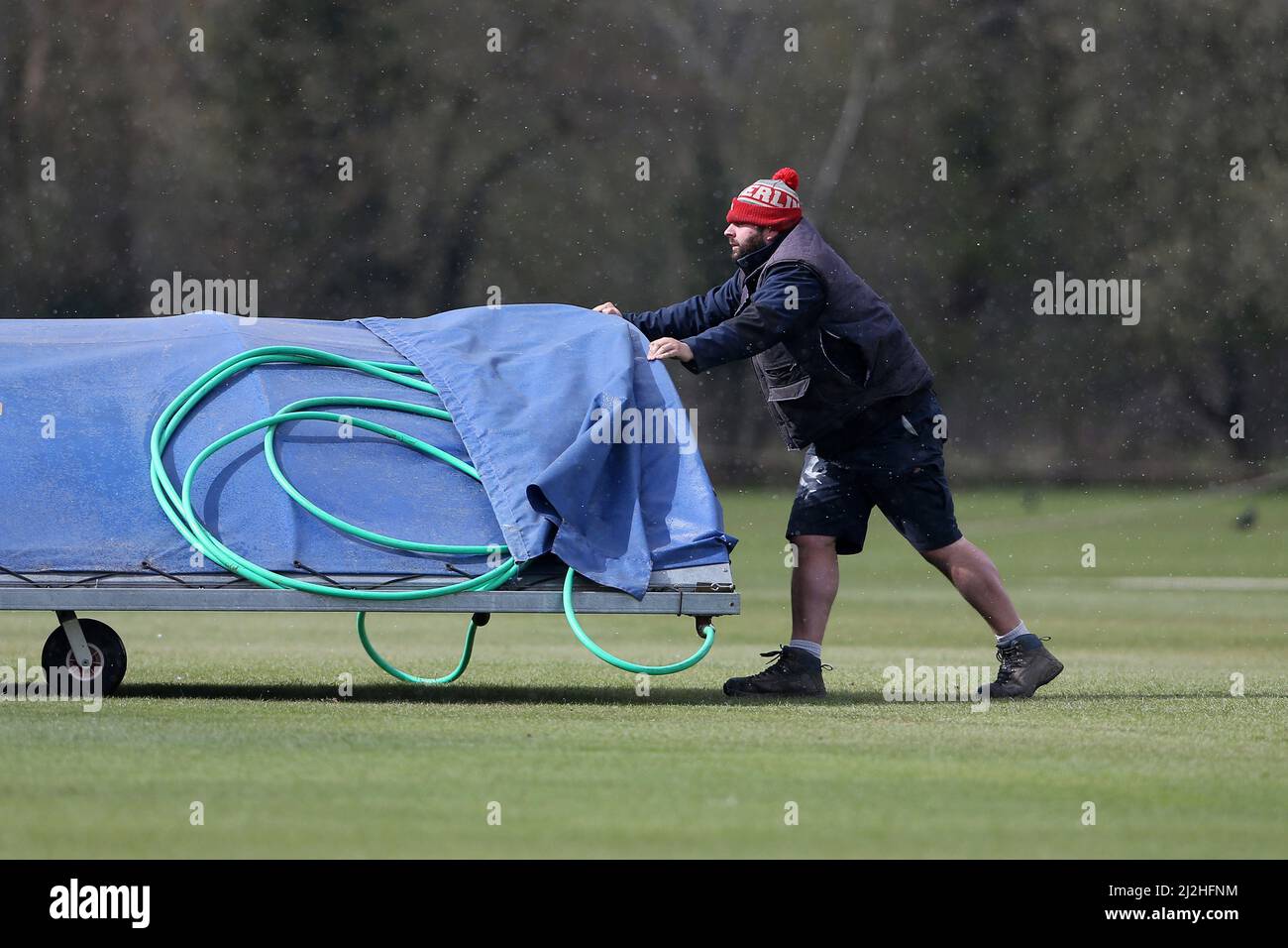 The covers are brought on during a brief snow shower during Middlesex ...
