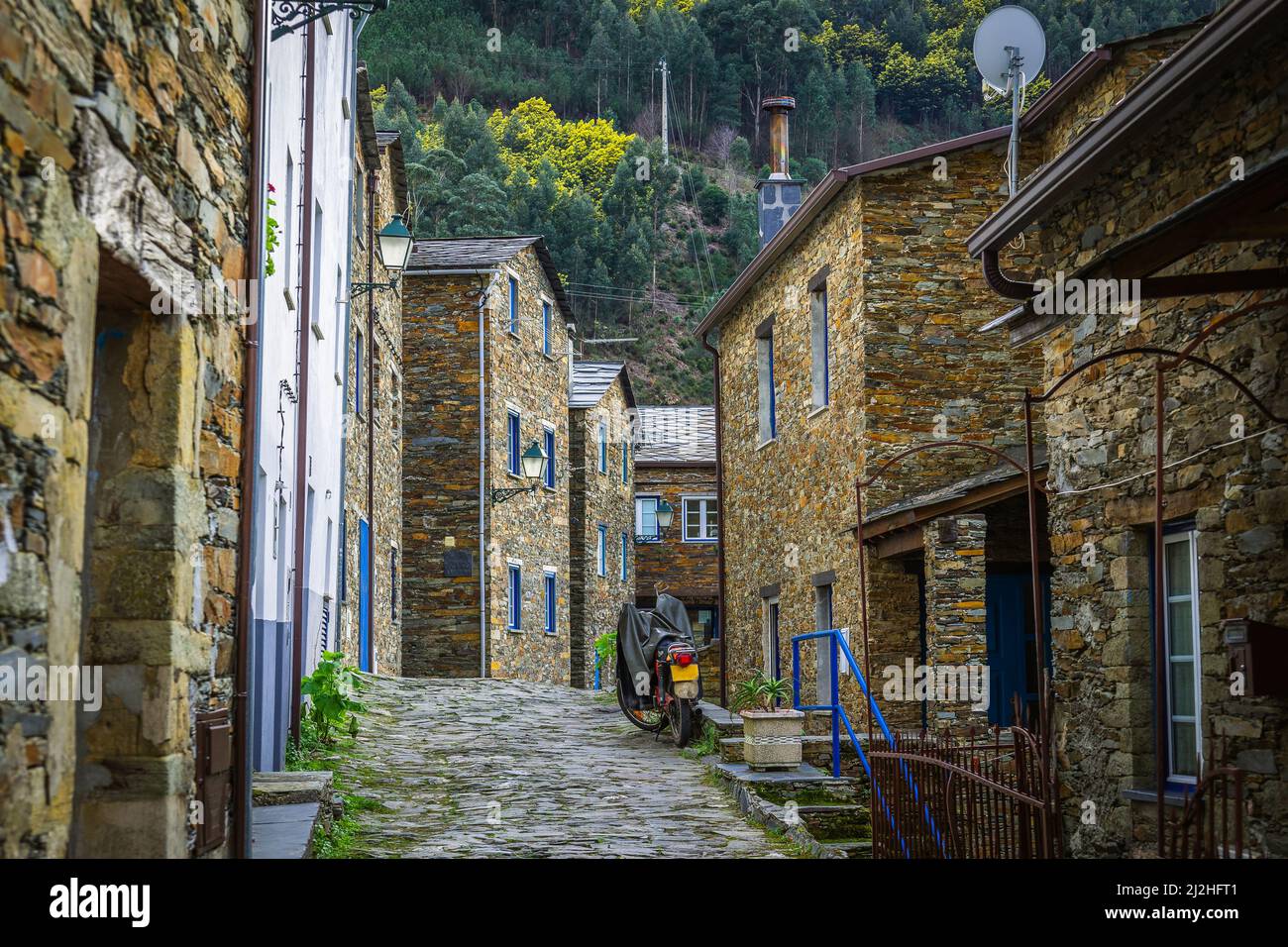 A narrow street between stone houses in Piodao, Aldeias de Xisto ...
