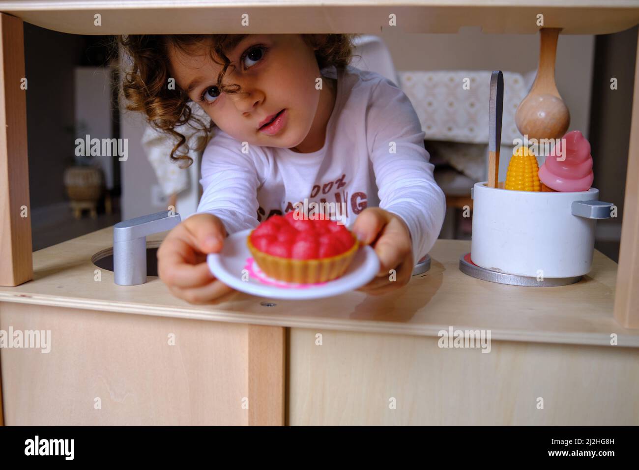 Little girl delivering cake plate in toy kitchen at home Stock Photo ...