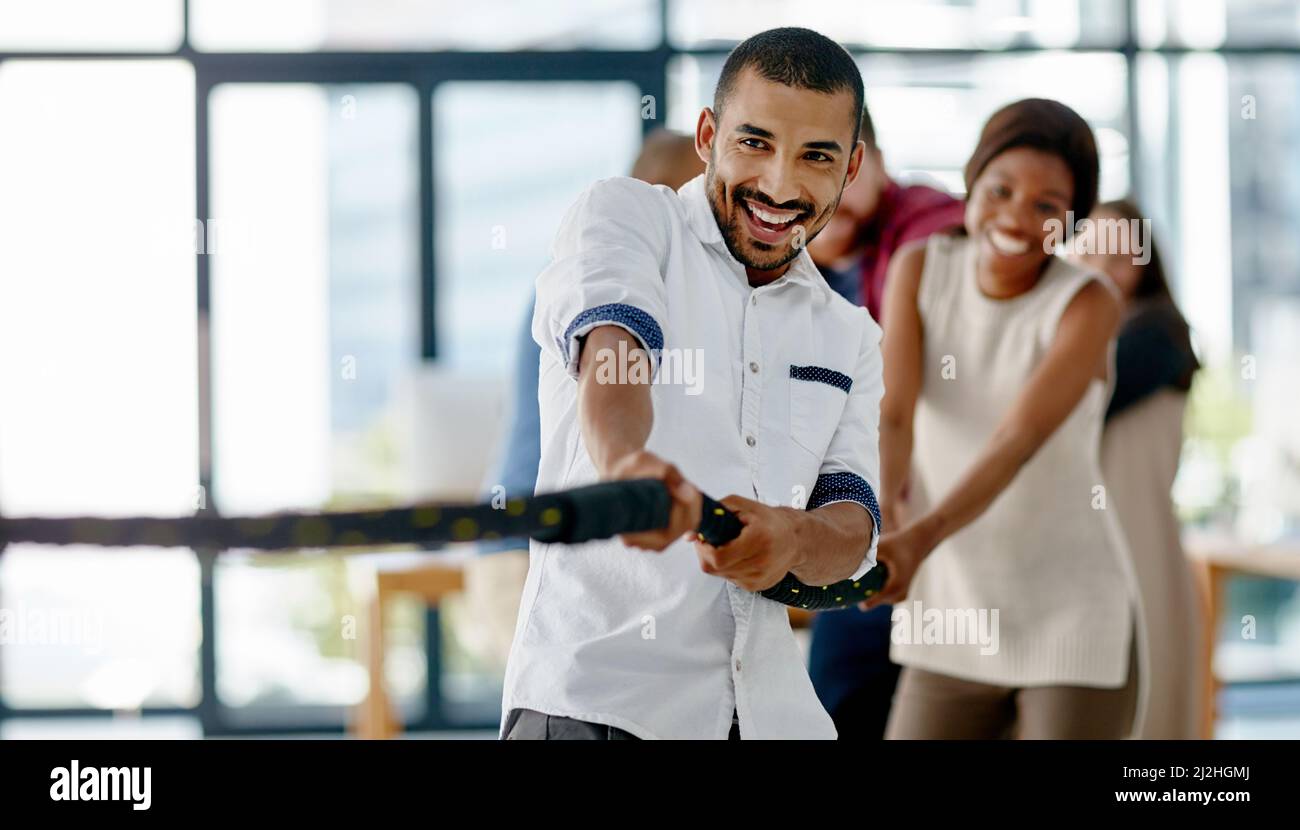 Weve got this. Cropped shot of a group of young designers pulling on a ...