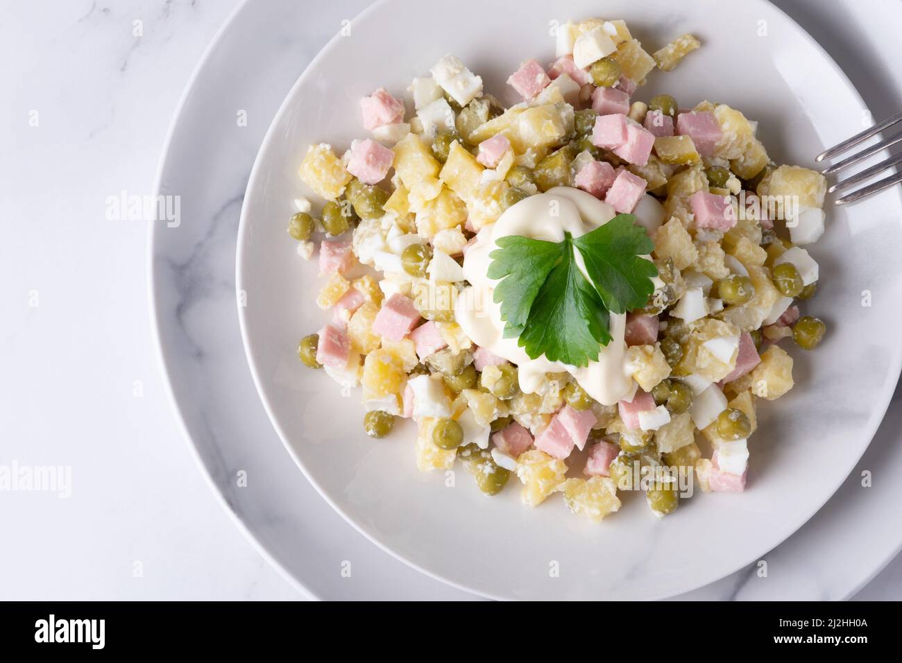 Russian olivier salad decorated with parsley. Top view Stock Photo - Alamy