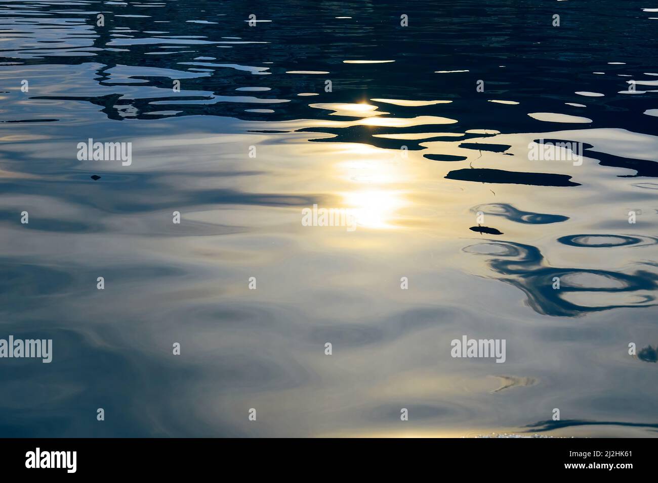 Reflection of the warm sun on the water ripples. Abstract nature ...