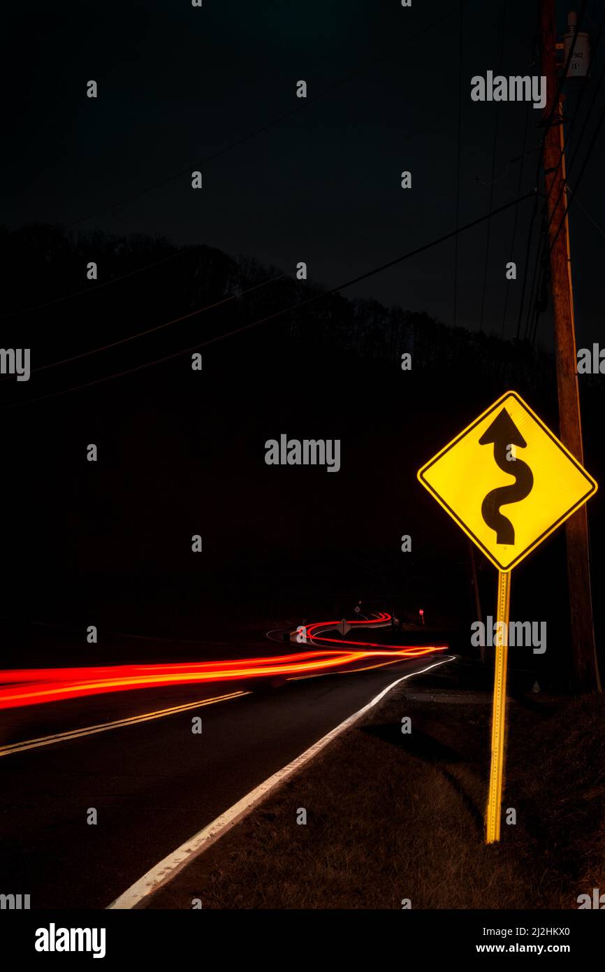 A vertical long exposure shot of an empty street at night with car ...