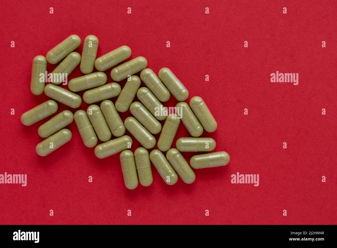 a closeup shot of brown pills on red background Stock Photo - Alamy
