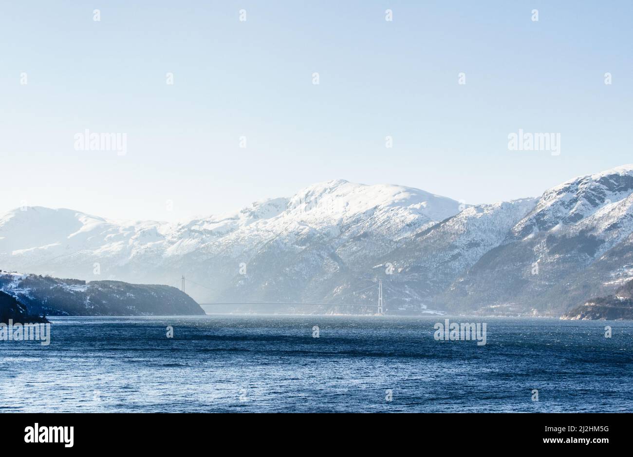 A tranquil scenery of the Hardangerfjord fjord and the Hardanger Bridge ...