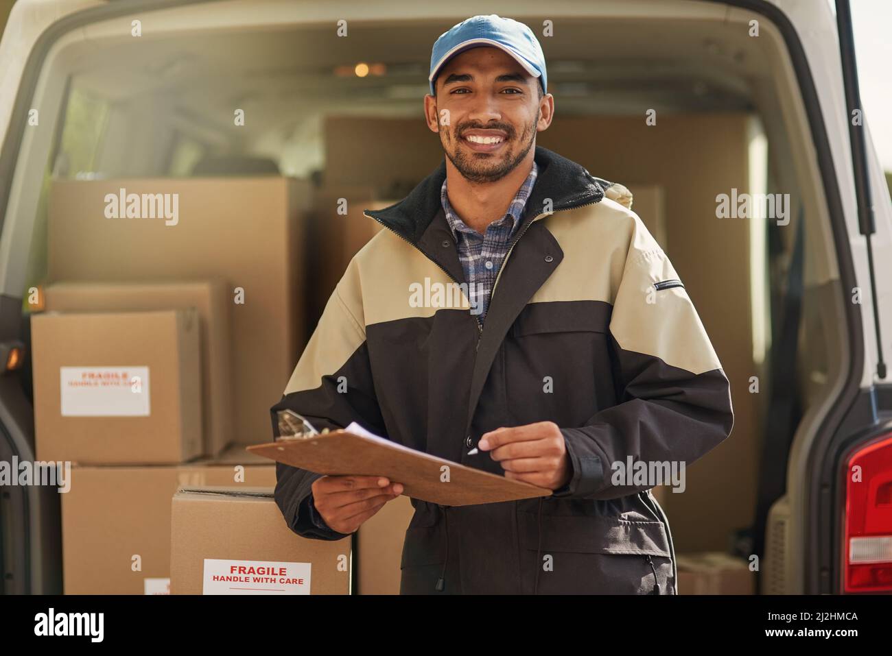Deliveries are right on schedule. Portrait of a smiling delivery man ...