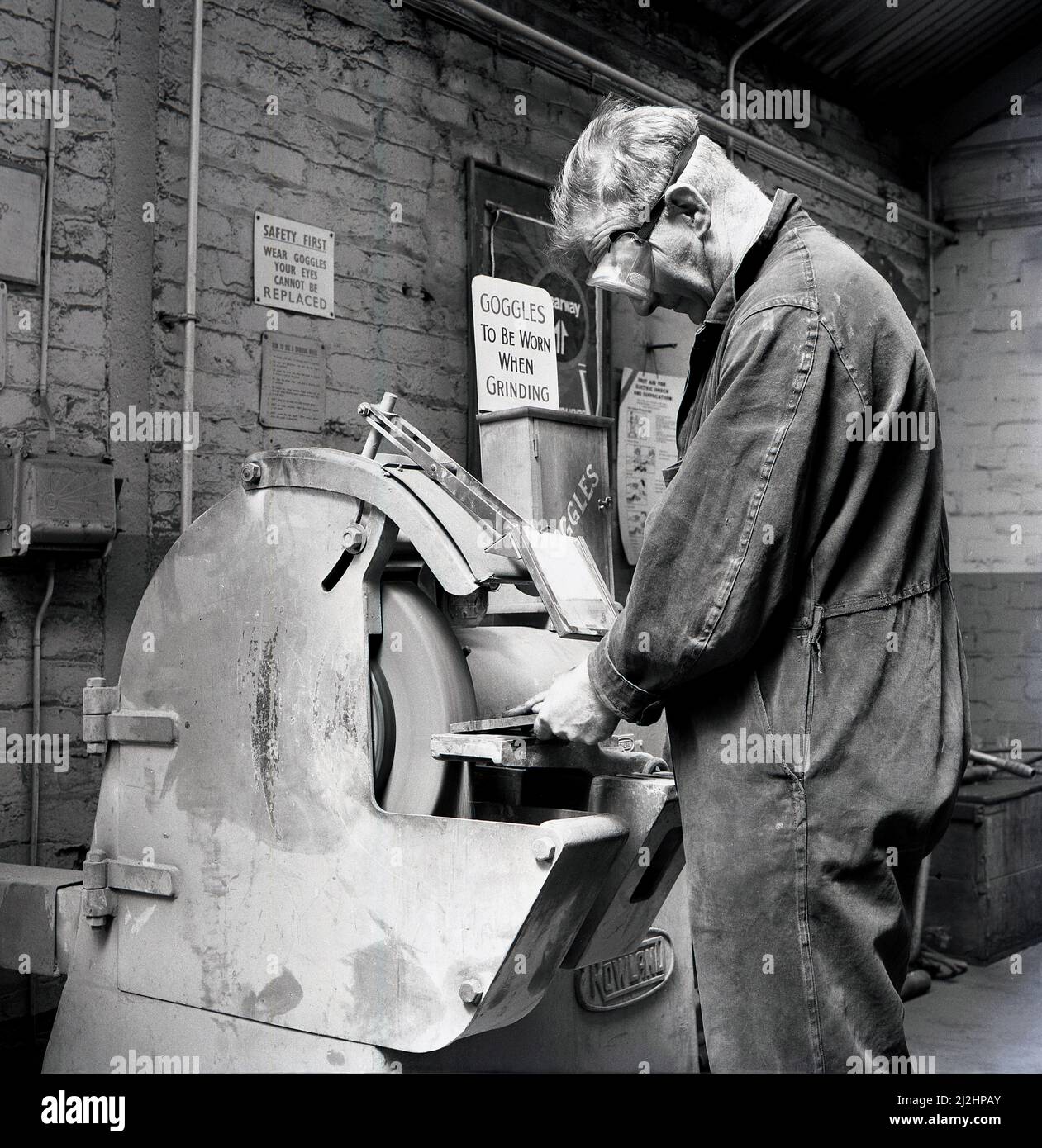 1950s, historical, a worker at a steel plant using a grinding machine ...