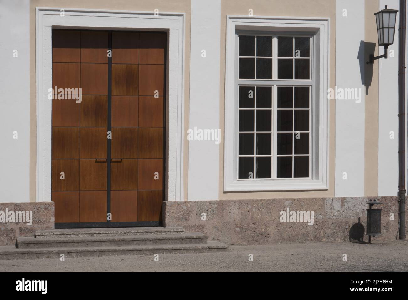 large solid wooden door next to a large barred window in an old well ...