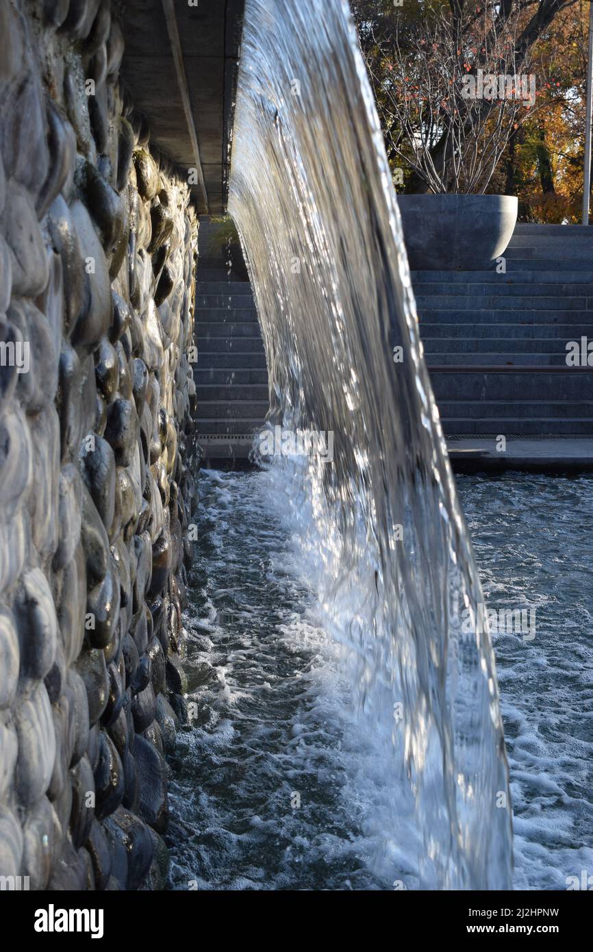 A waterfall flowing at park. A waterfall of a fountain in a garden ...