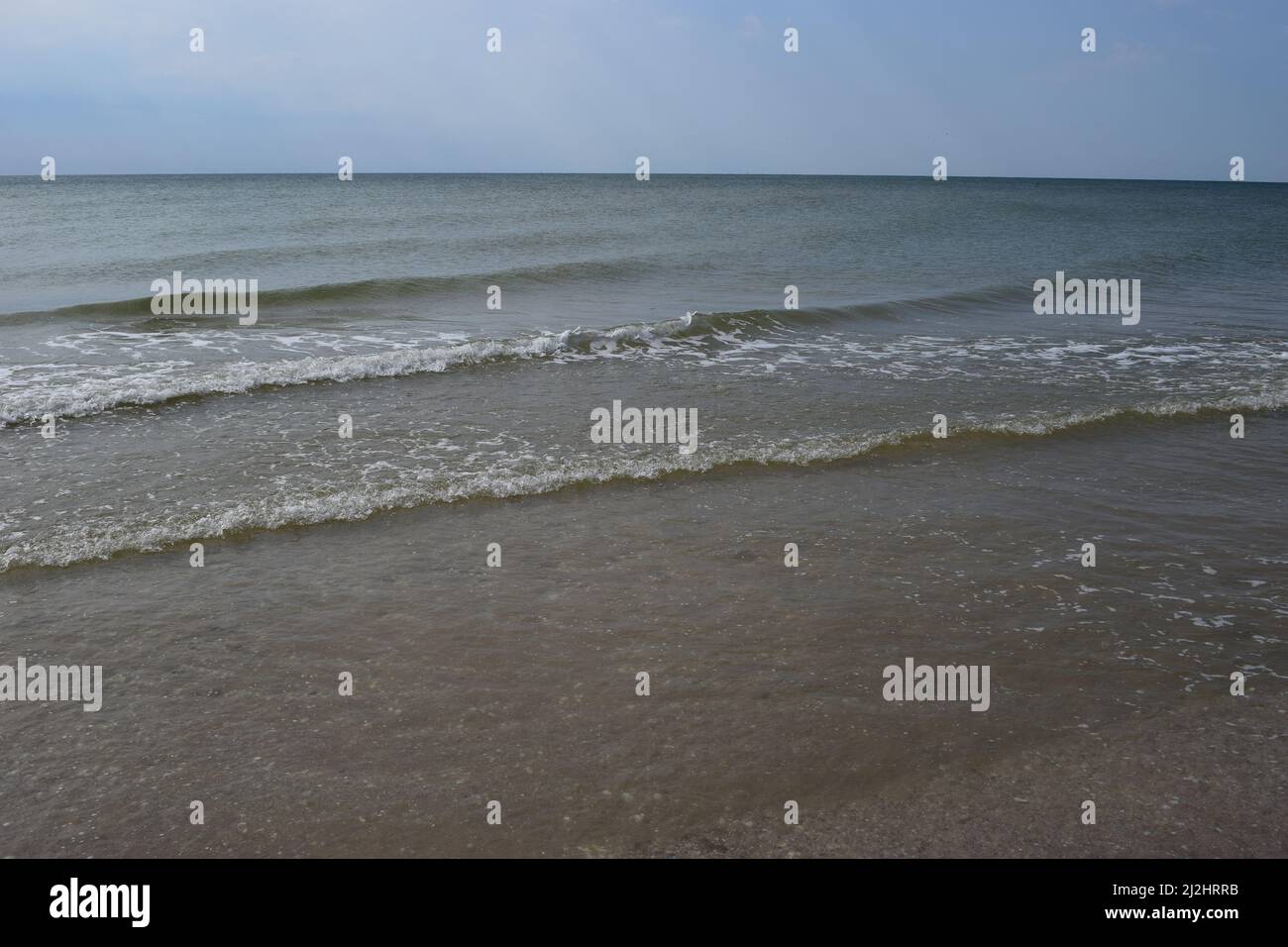 Beautiful landscape - turquoise colored sea water, sand, sky. The waves ...