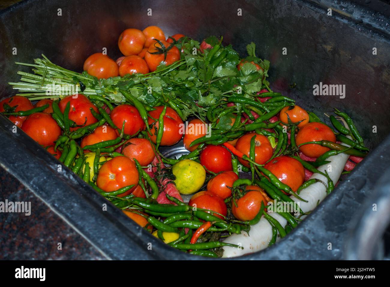 A close up shot of vegetables being washed in a sink in order to get ...