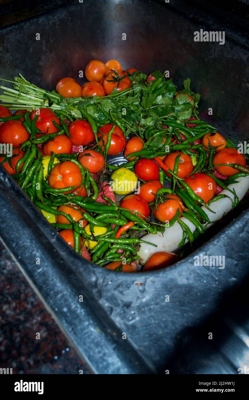 A close up shot of vegetables being washed in a sink in order to get ...