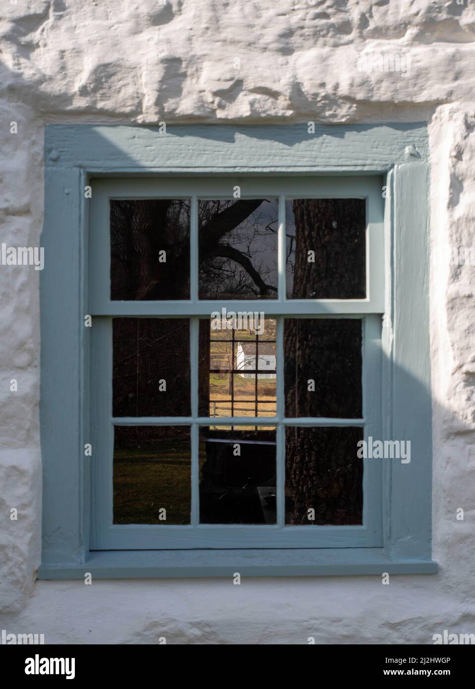 View of rural landscape through colonial American stone cottage window ...