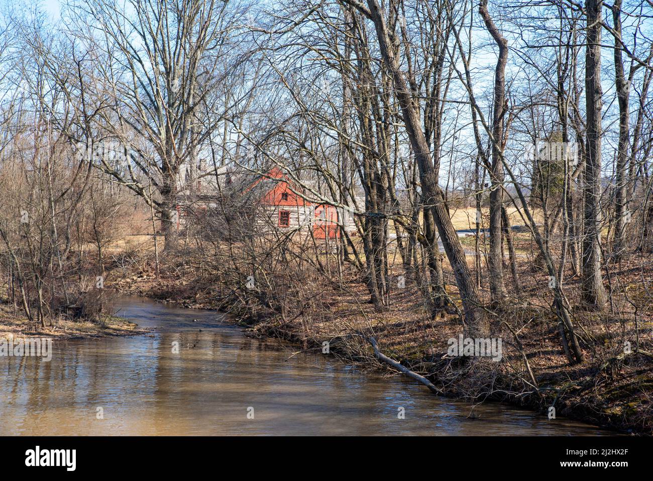 Colonial American log cabin in the woods by a river Stock Photo - Alamy