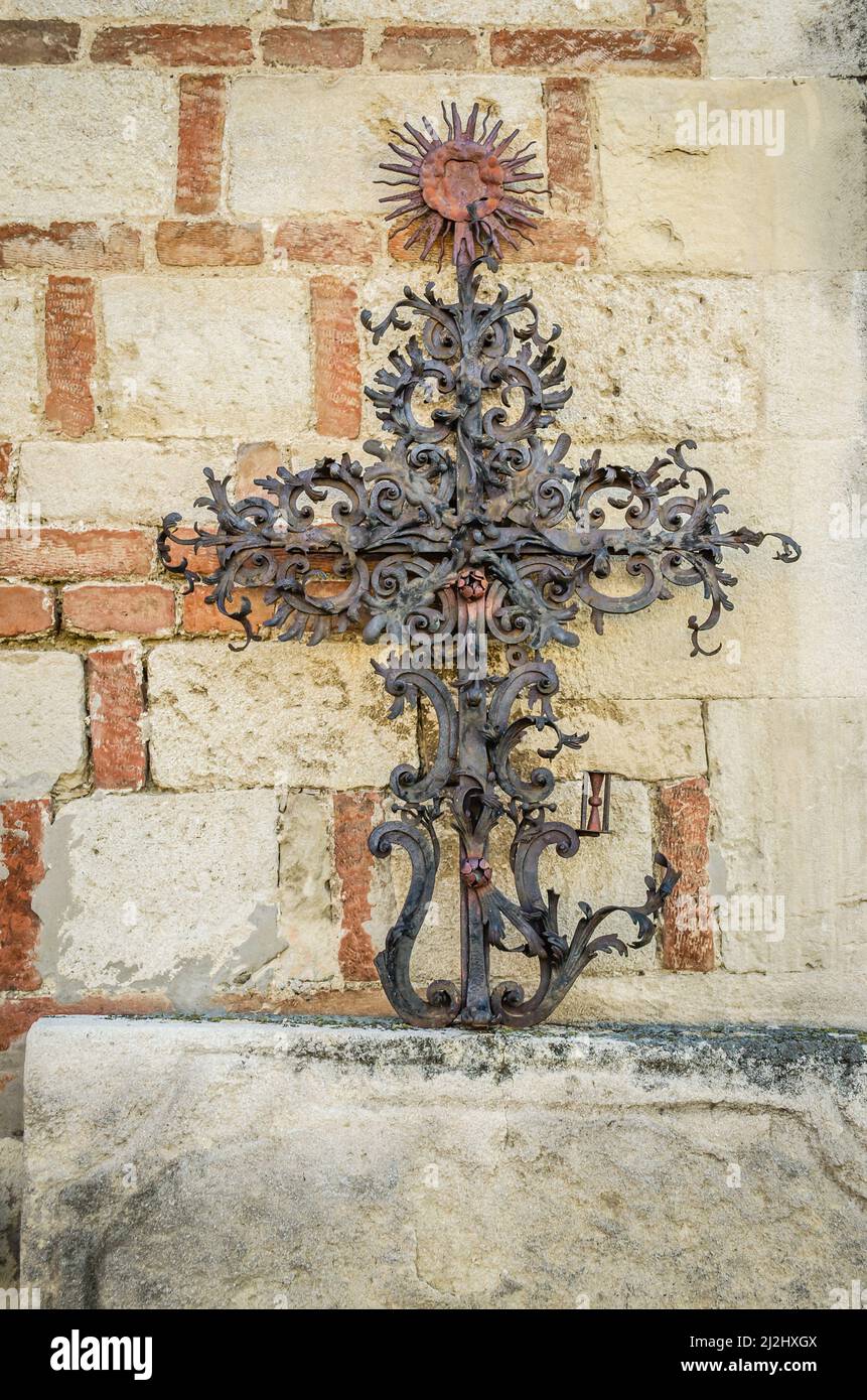 Forged steel cross, leaning against the church wall in the courtyard ...