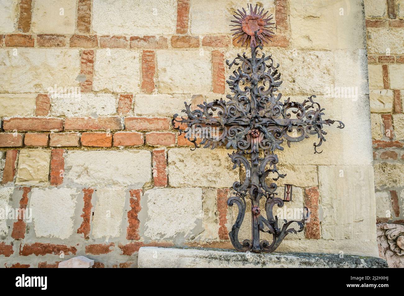 Forged steel cross, leaning against the church wall in the courtyard ...