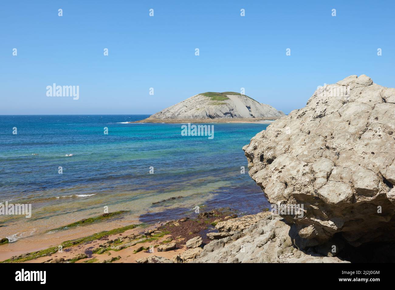 Steep cliffs next to a calm sea with a beautiful blue sky Stock Photo ...