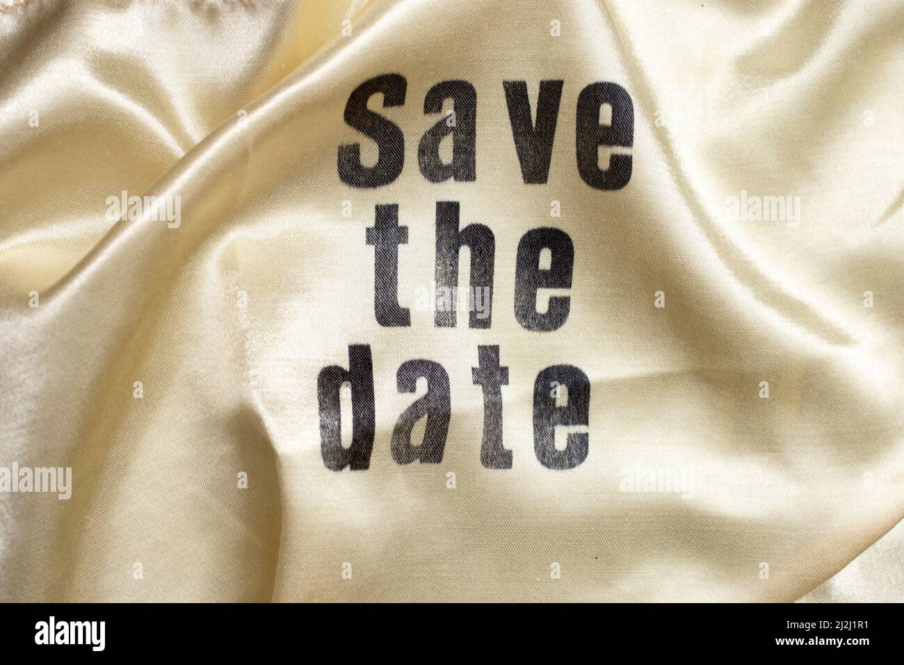 Save the date written on golden satin fabric Stock Photo - Alamy
