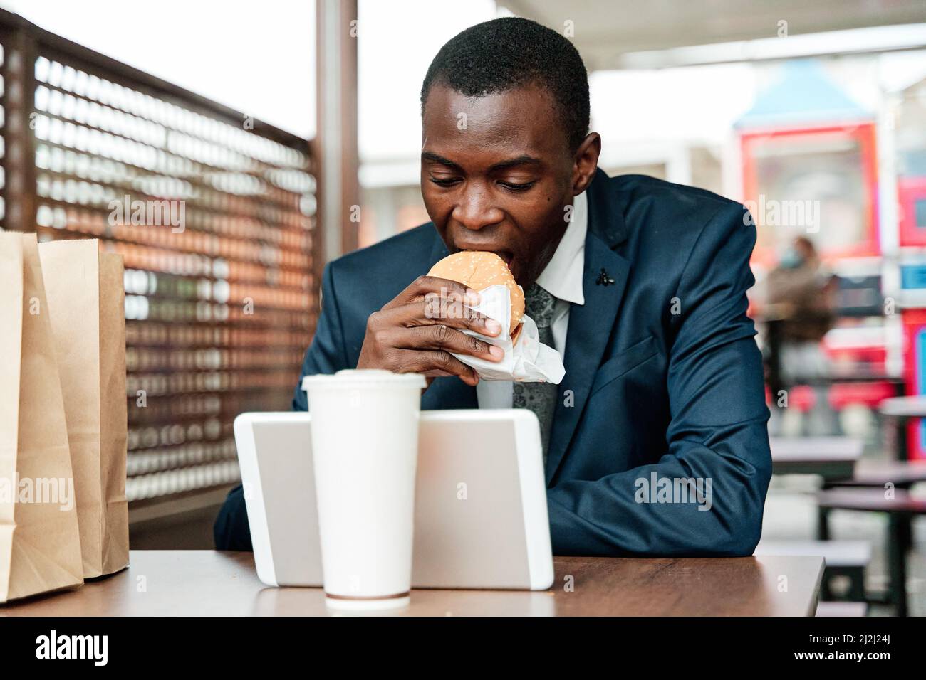 african american businessman in suit sitting in restaurant, eating ...