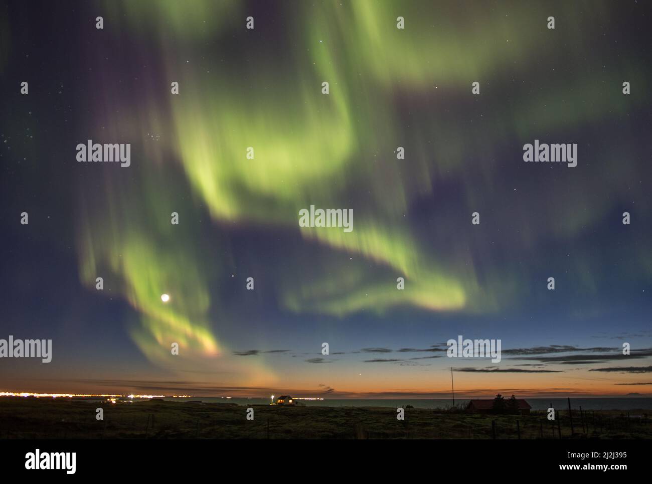 Intense aurora borealis over a small city in Iceland Stock Photo - Alamy