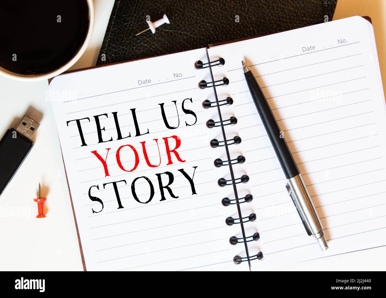 TELL US YOUR STORY text on white paper Stock Photo - Alamy