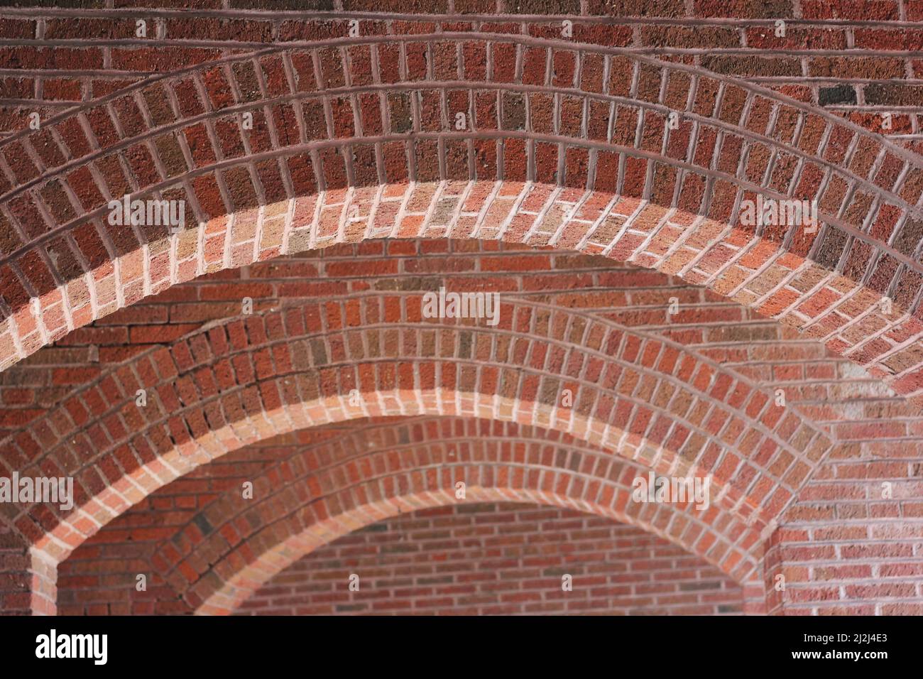 Arcade of vintage brick arches outside on the ground level in black and ...